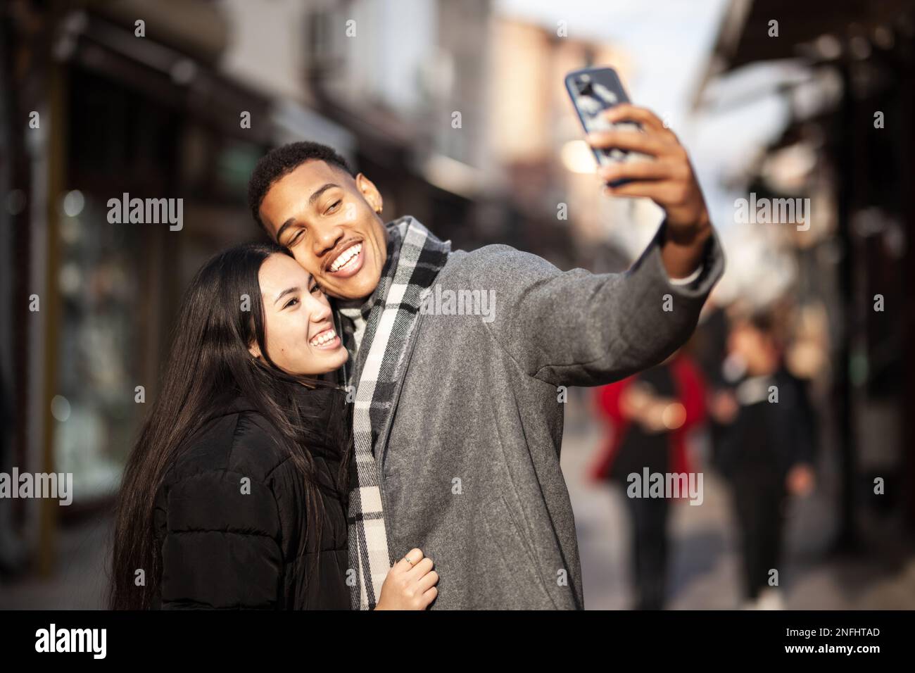Multiracial couple posing on narrow streets in old part of the sity ...