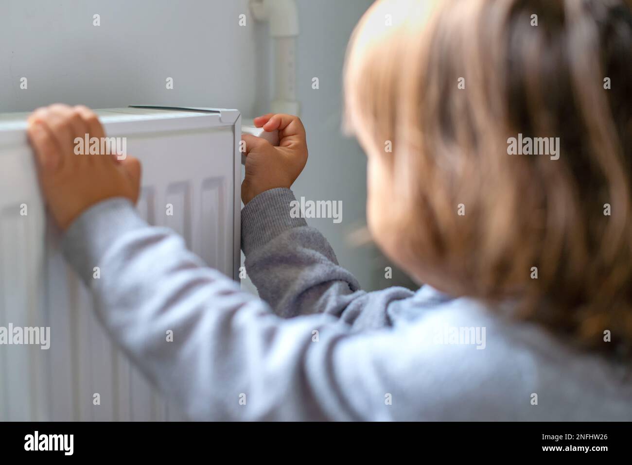 A small child who gives more heat to the radiator because she is cold ...