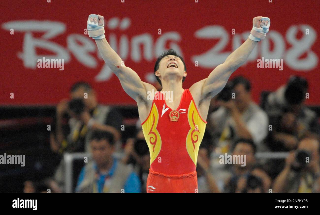 China's gymnast Li Xiaopeng raises his arms after performing during the ...