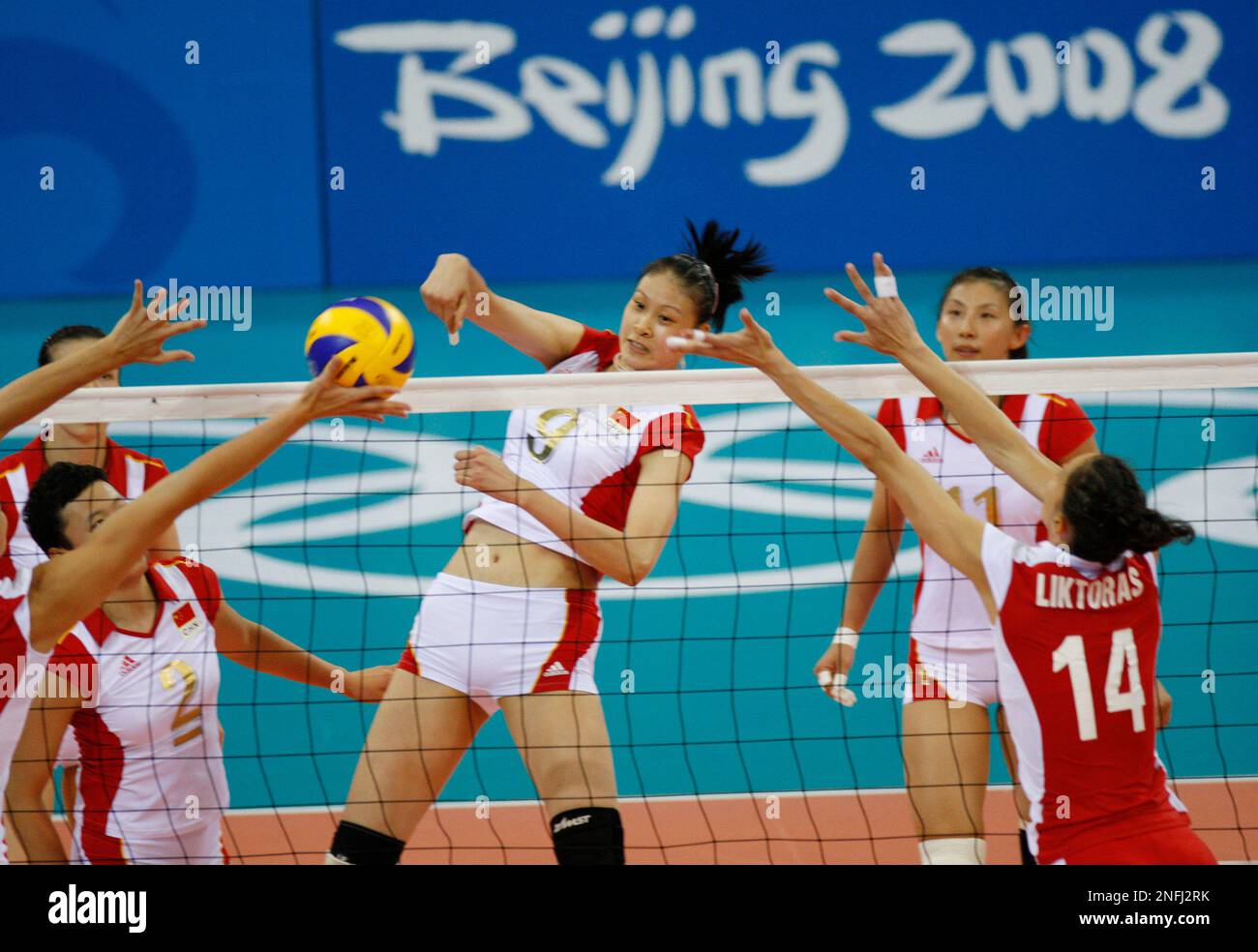 China's Zhao Ruirui, center, spikes the ball as Poland's Maria Liktoras ...