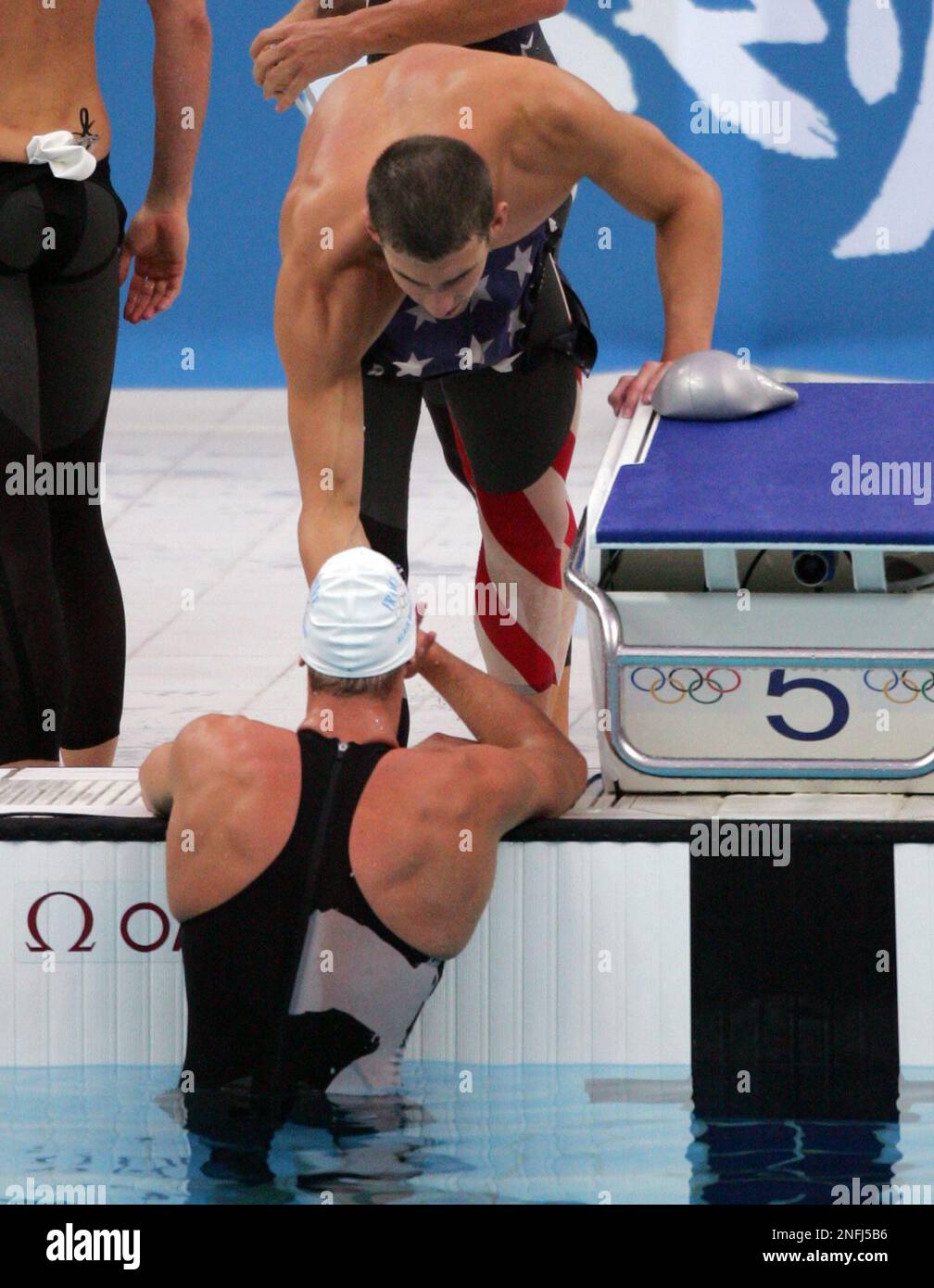 Michael Phelps of the United States, top, greets his relay team anchor ...