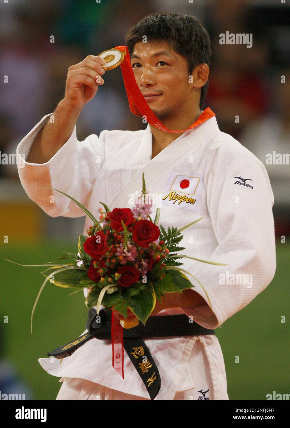 Japan's Masato Uchishiba holds up his gold medal during the judo half ...