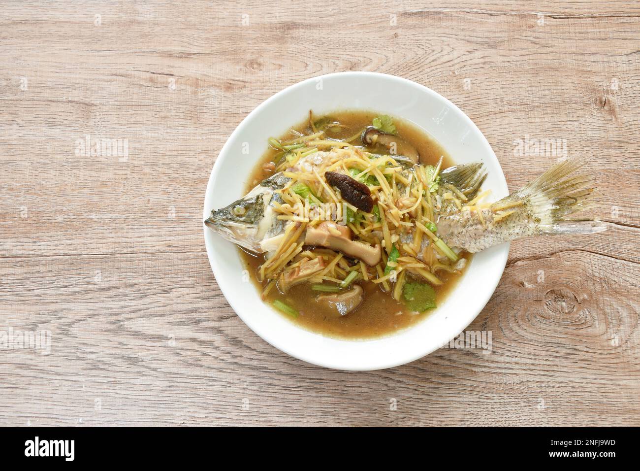 steamed bass fish dressing soybean gravy sauce topping slice ginger and ...