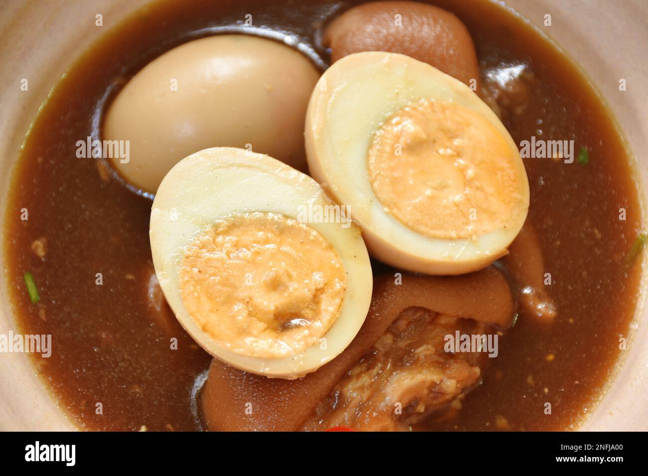 boiled half cut egg with fat pork leg in herb brown soup on bowl Stock ...