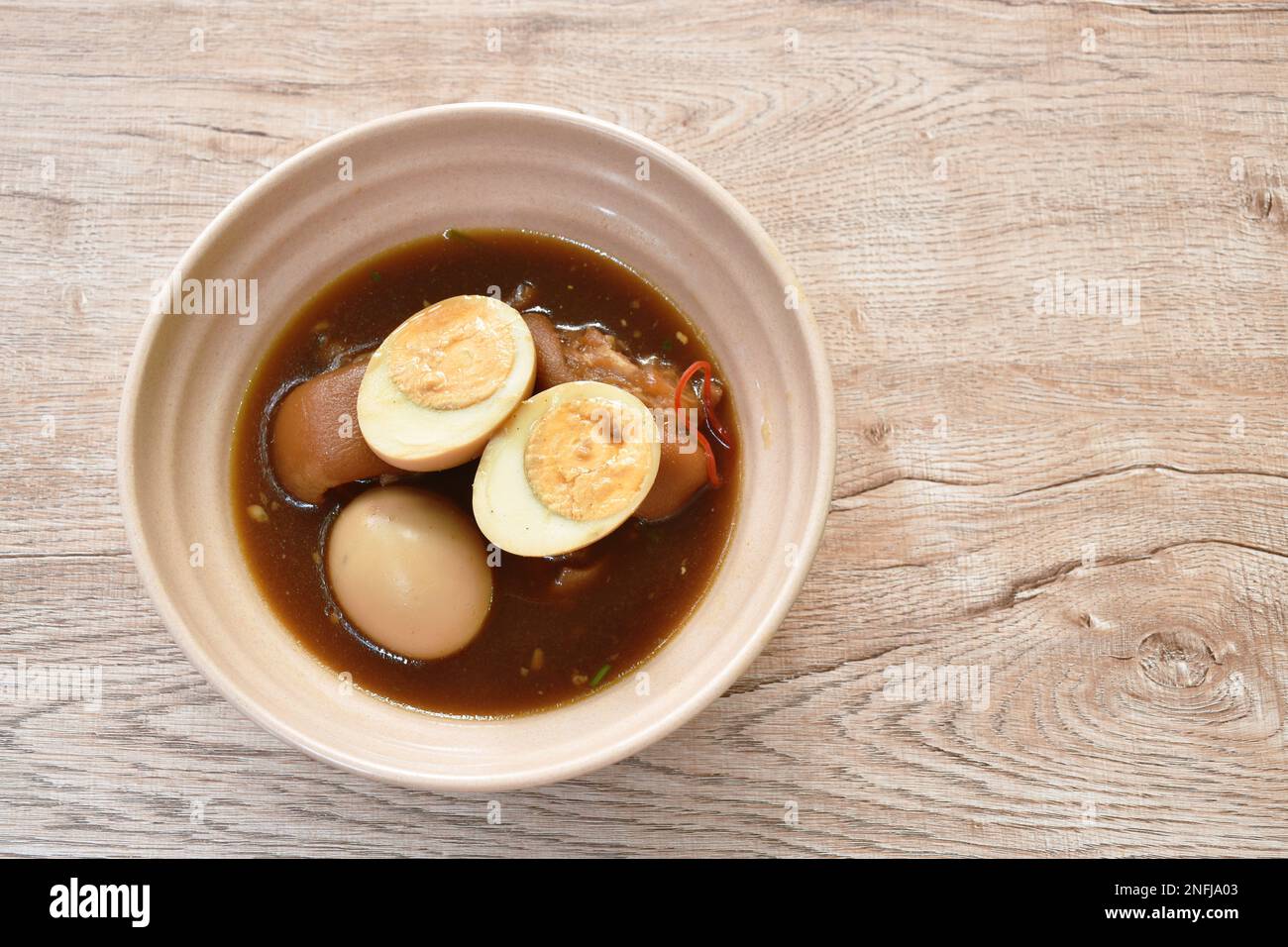 boiled half cut egg with fat pork leg in herb brown soup on bowl Stock ...