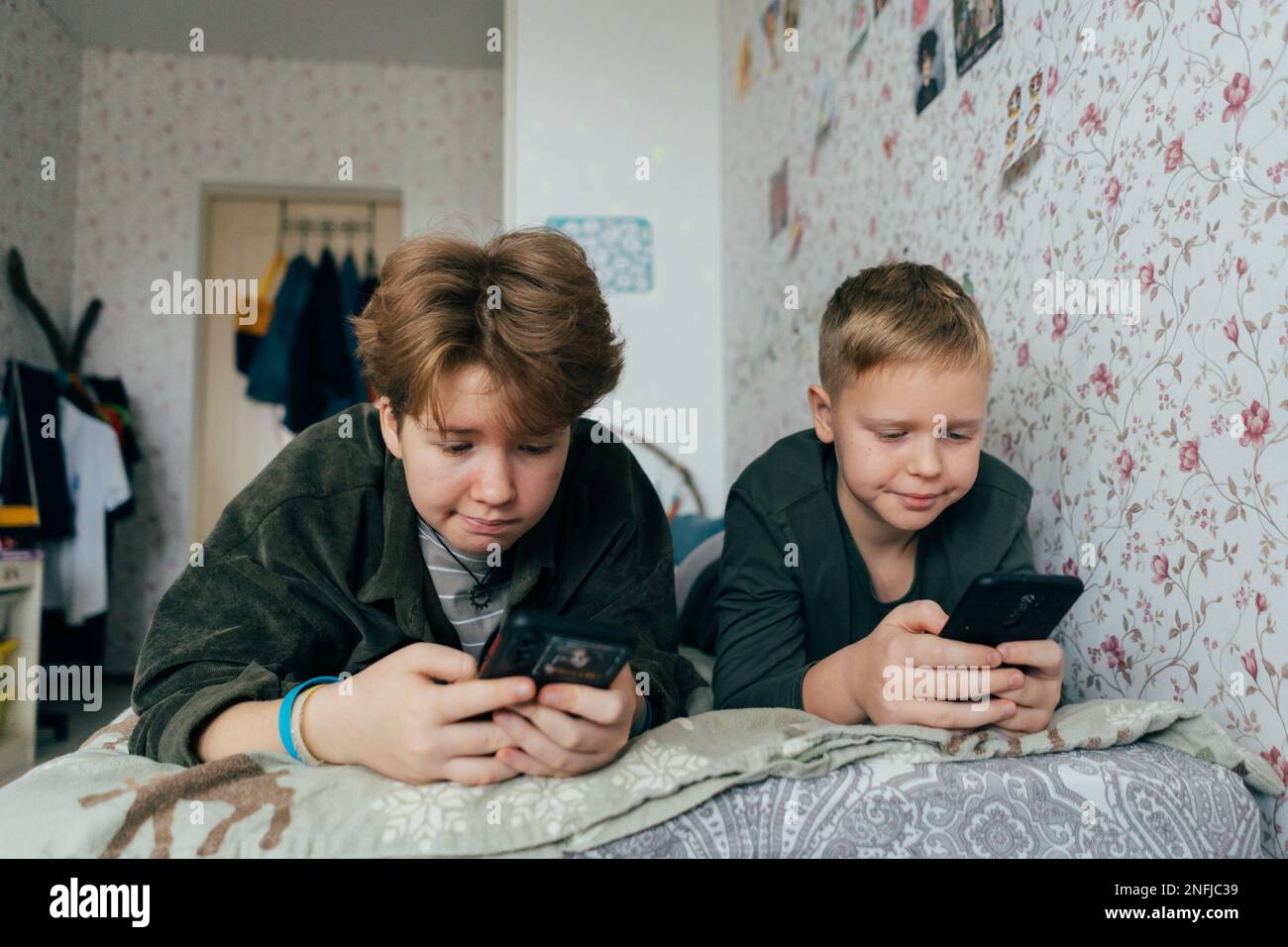 Children enjoy playing the game on the phone while lying on the bed ...