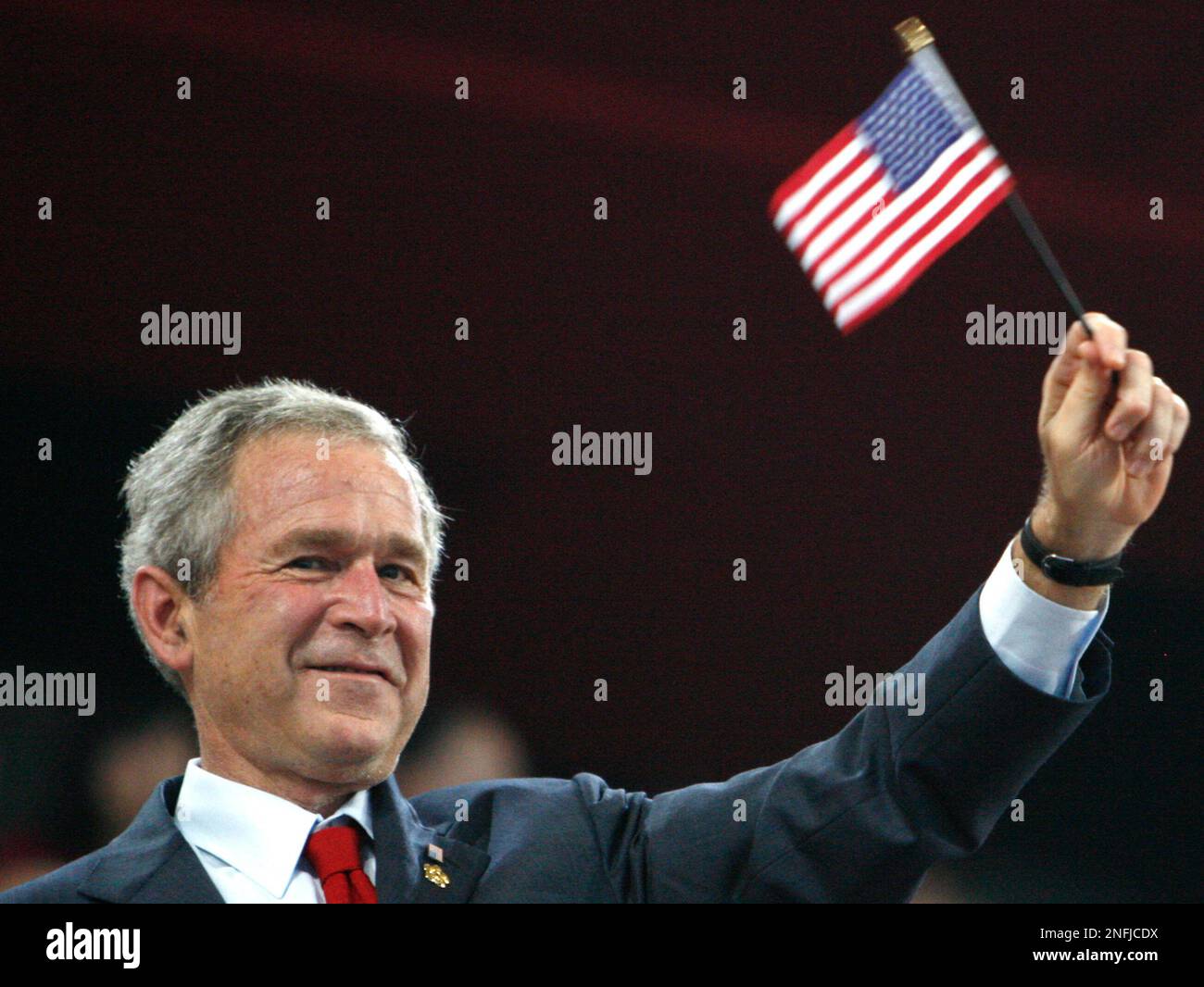 U.S. President George Bush waves an American flag as the U.S. Olympic ...