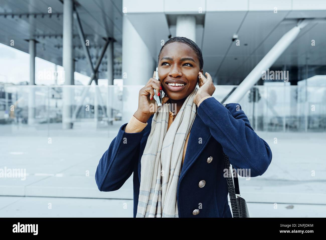 Beautiful young african woman using mobile phone in the street Stock ...