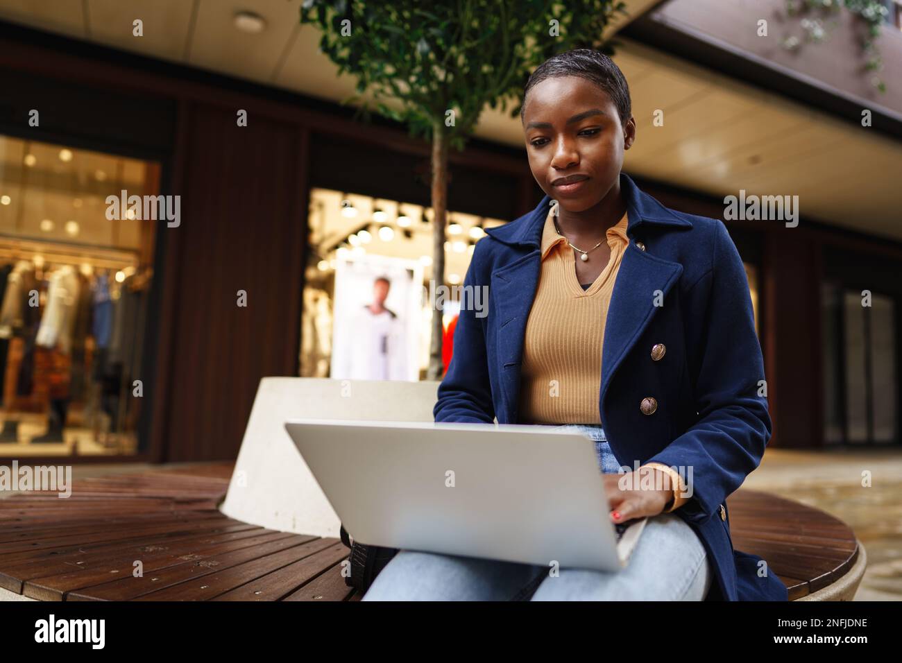 African female student working on computer in public place Stock Photo ...