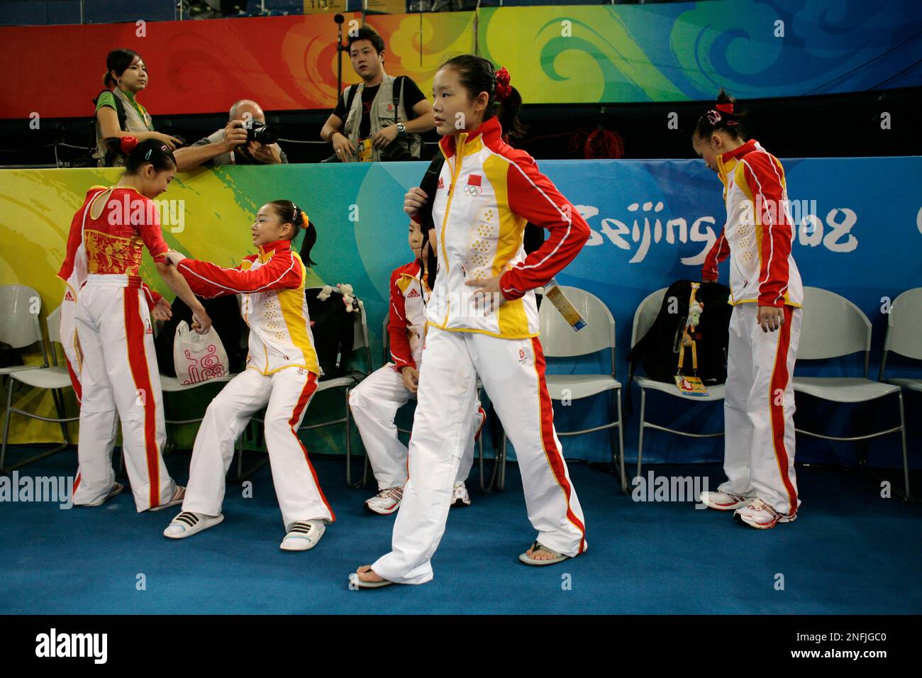 Chinese gymnast Cheng Fei, center, leaves the balance beam area to ...