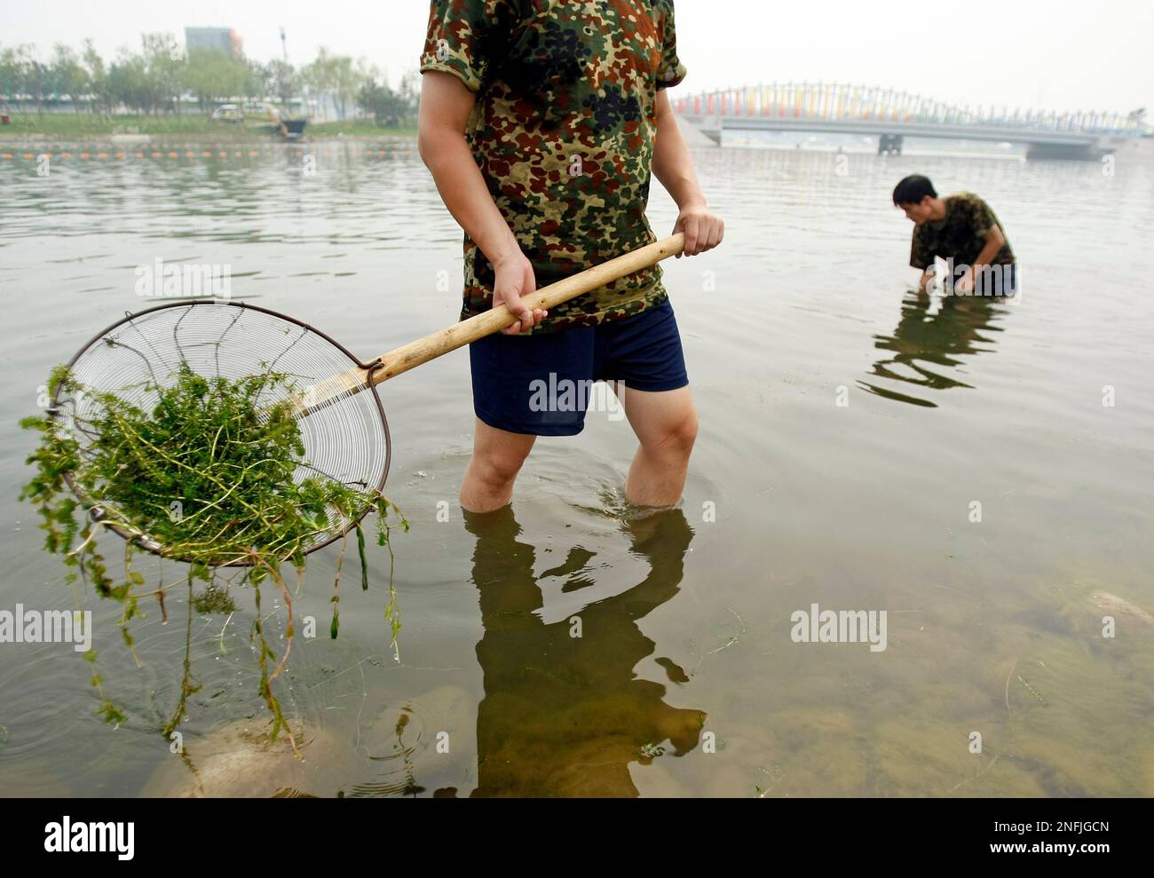 Chinese officials remove plants from the rowing and canoe venue during ...