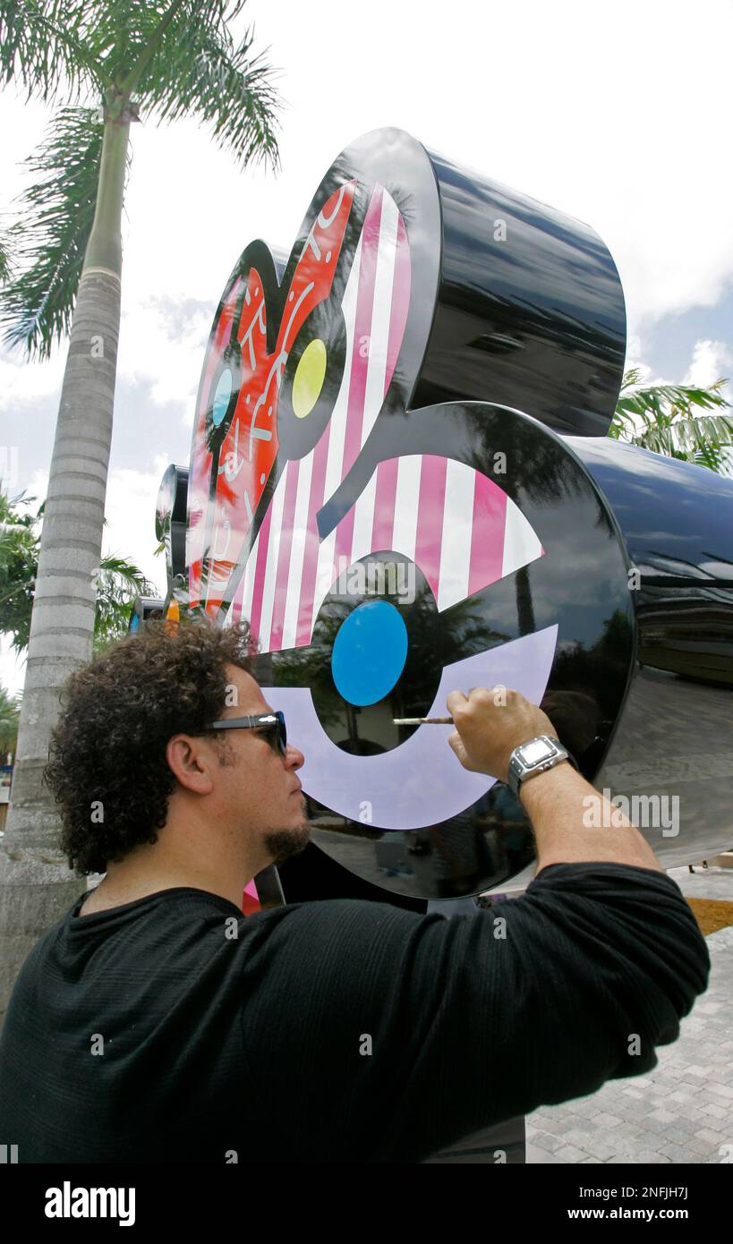Brazilian artist Romero Britto signs one of his sculptures in Miami ...