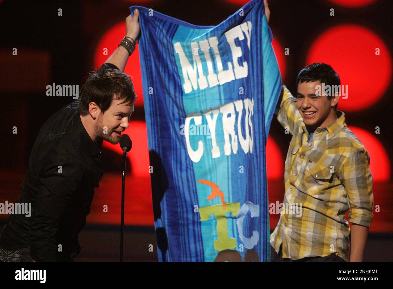 David Cook, left, and David Archuleta present an award to Miley Cyrus ...