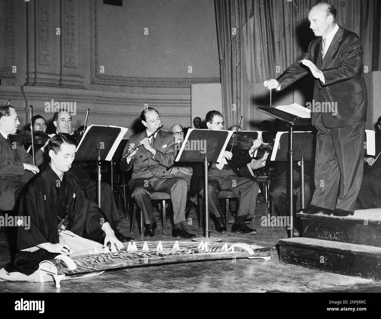 Soloist Shinichi Yuize plays the koto, a long Japanese zither harp of ...