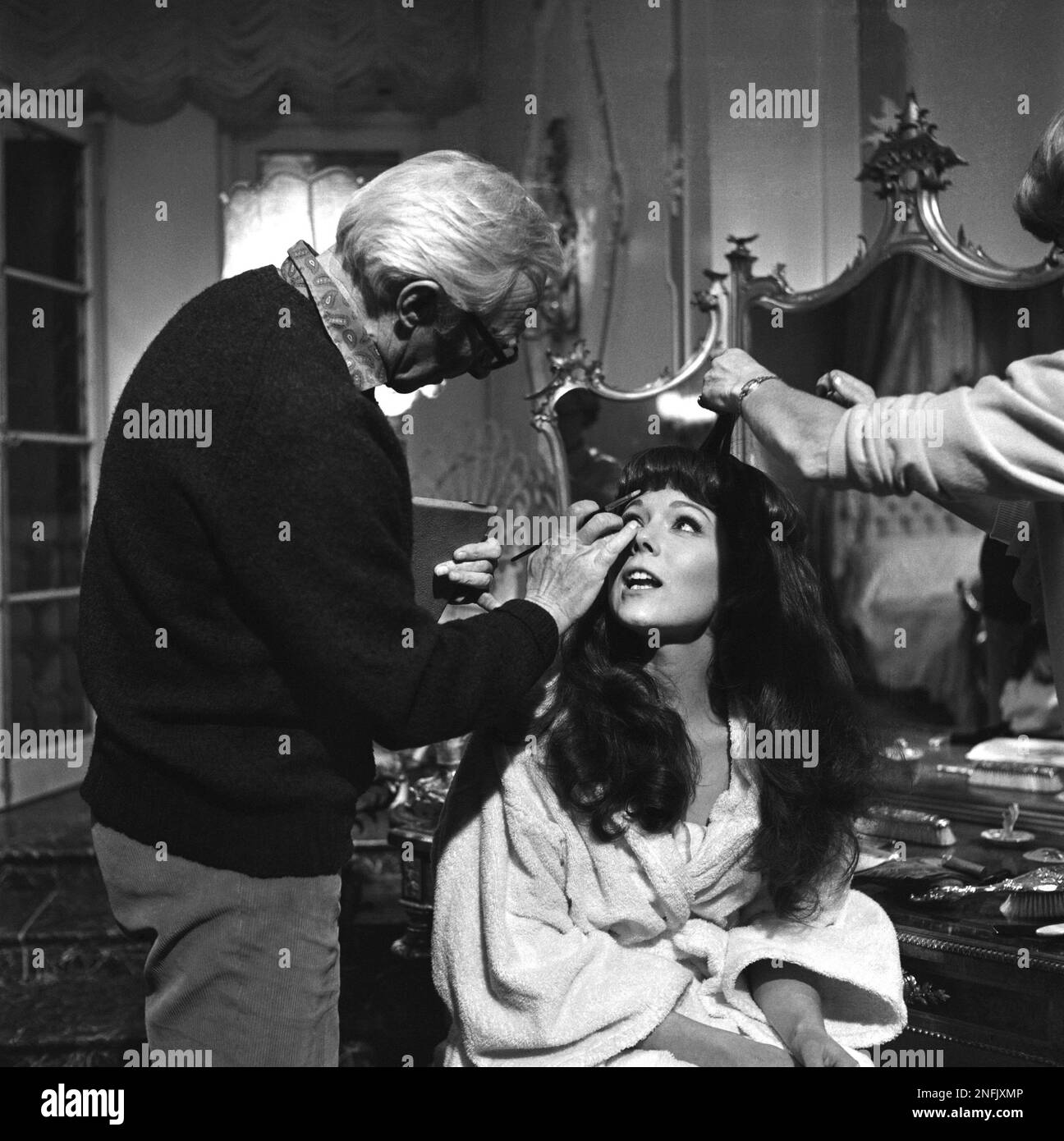 A make-up artist attends to British actress Diana Rigg on the set of ...