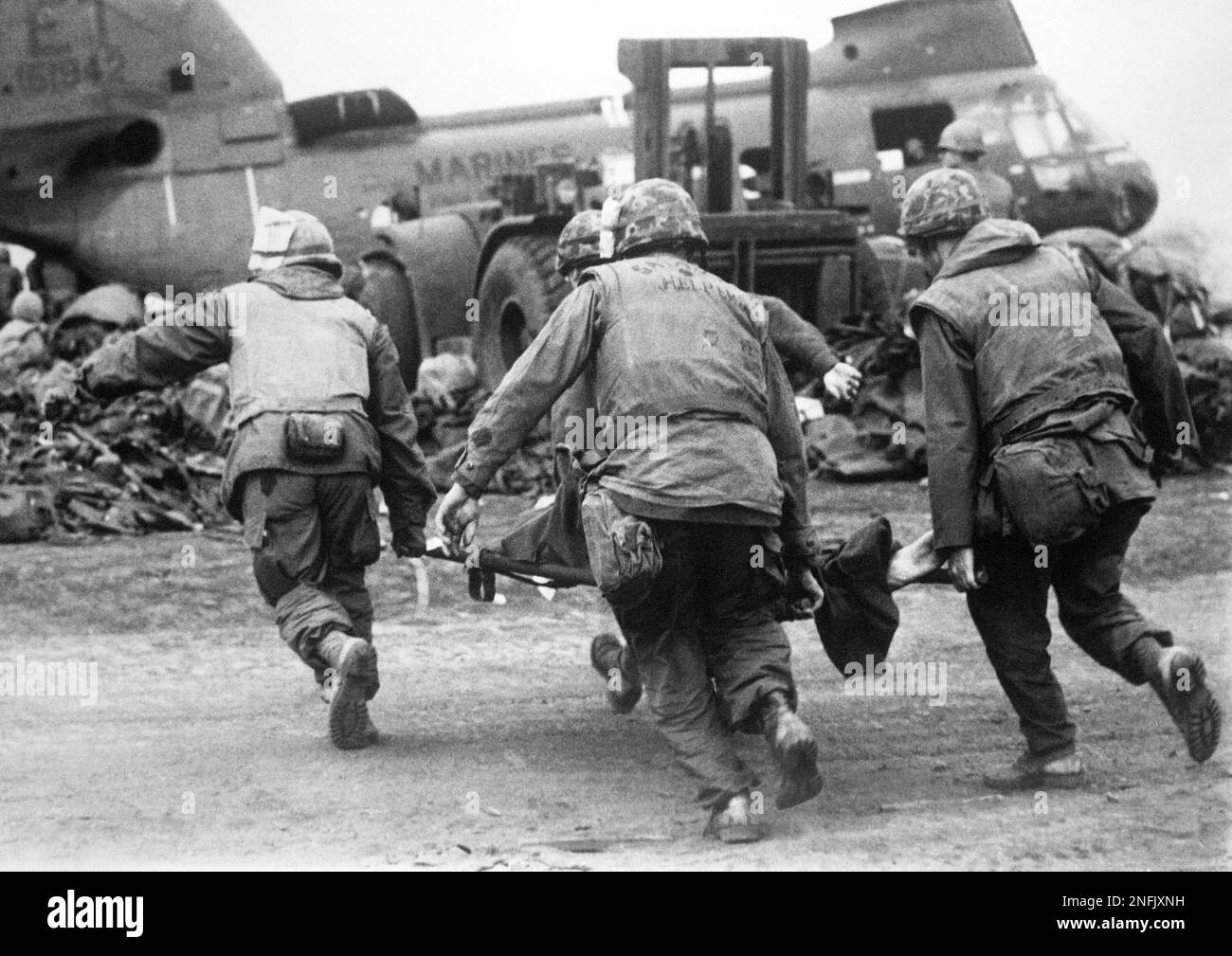 U.S. Marines carry a comrade, wounded in communist shelling to an ...