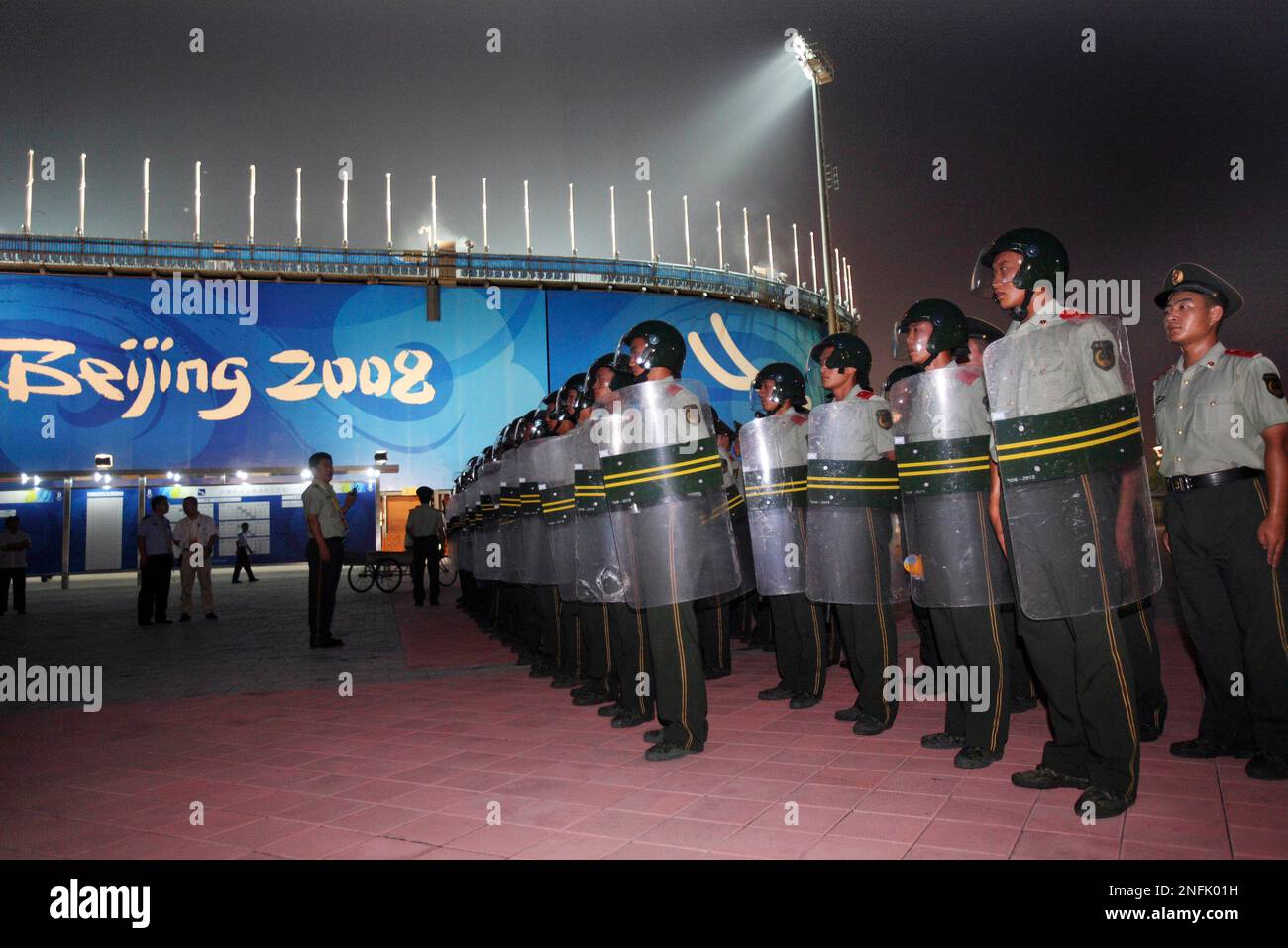 Chinese paramilitary police officers in anti-riot gear go through a ...