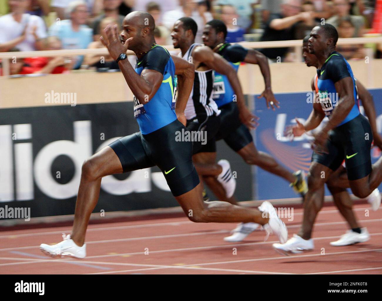 Asafa Powell of Jamaica, left, competes in the men's 100 meters race ...