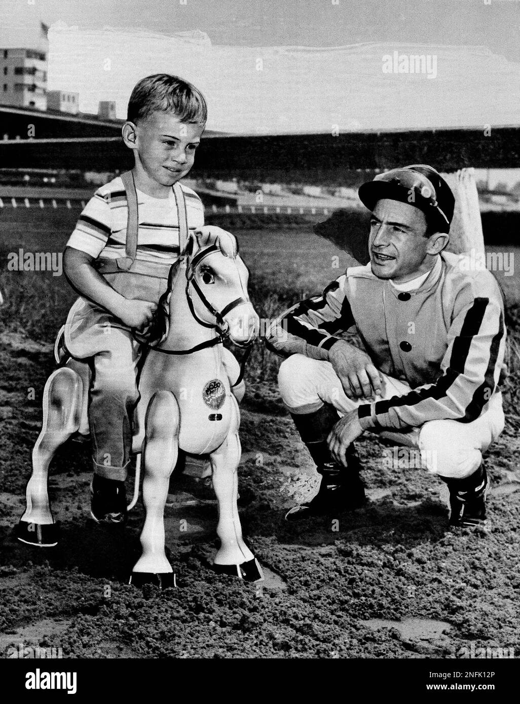 Famed Jockey Ted Atkinson gives his son Johnny, 3, some pointers on ...