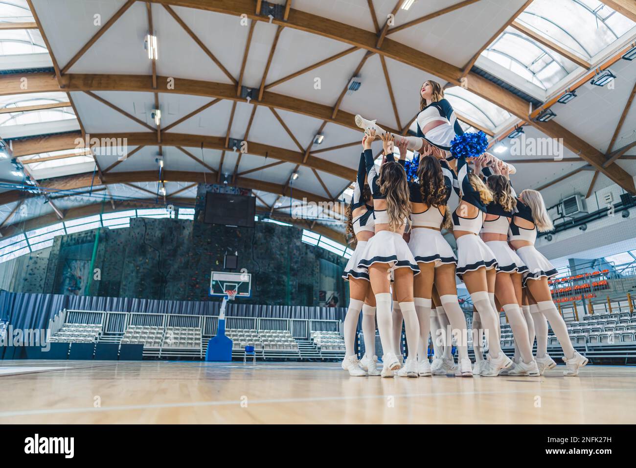 cheerleaders holding their team member up while doing a split, full ...