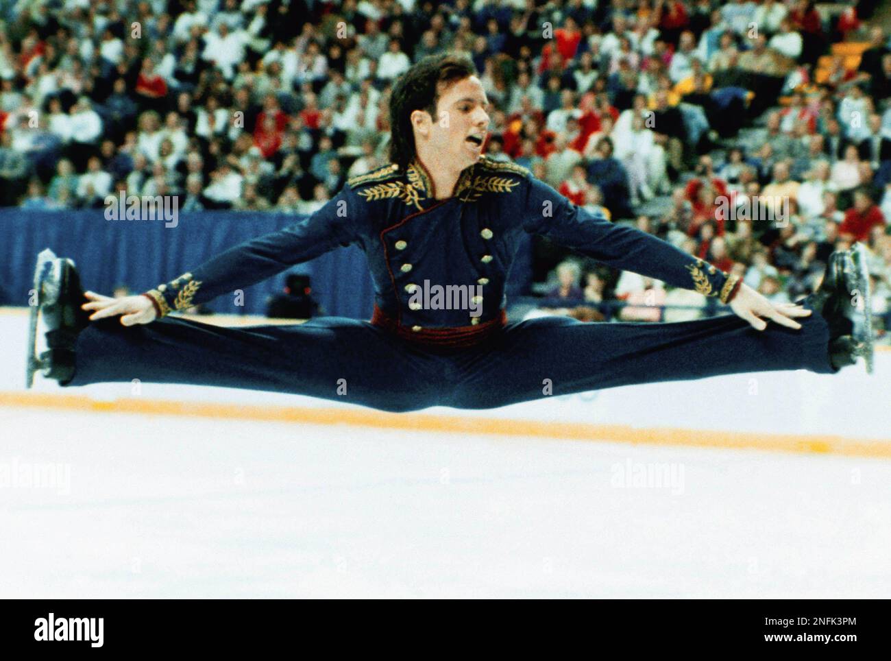 Brian Boitano of Sunnyvale, California leaps in the air, touching his ...