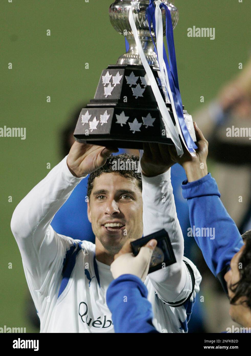 Impact de Montreal's Nevio Pizzolitto hoists the trophy after their ...