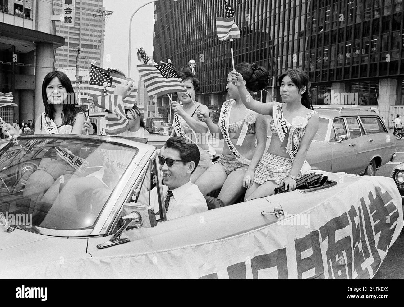 Bikini clad hostesses of a Tokyo cabaret, led by their manager, shout ...