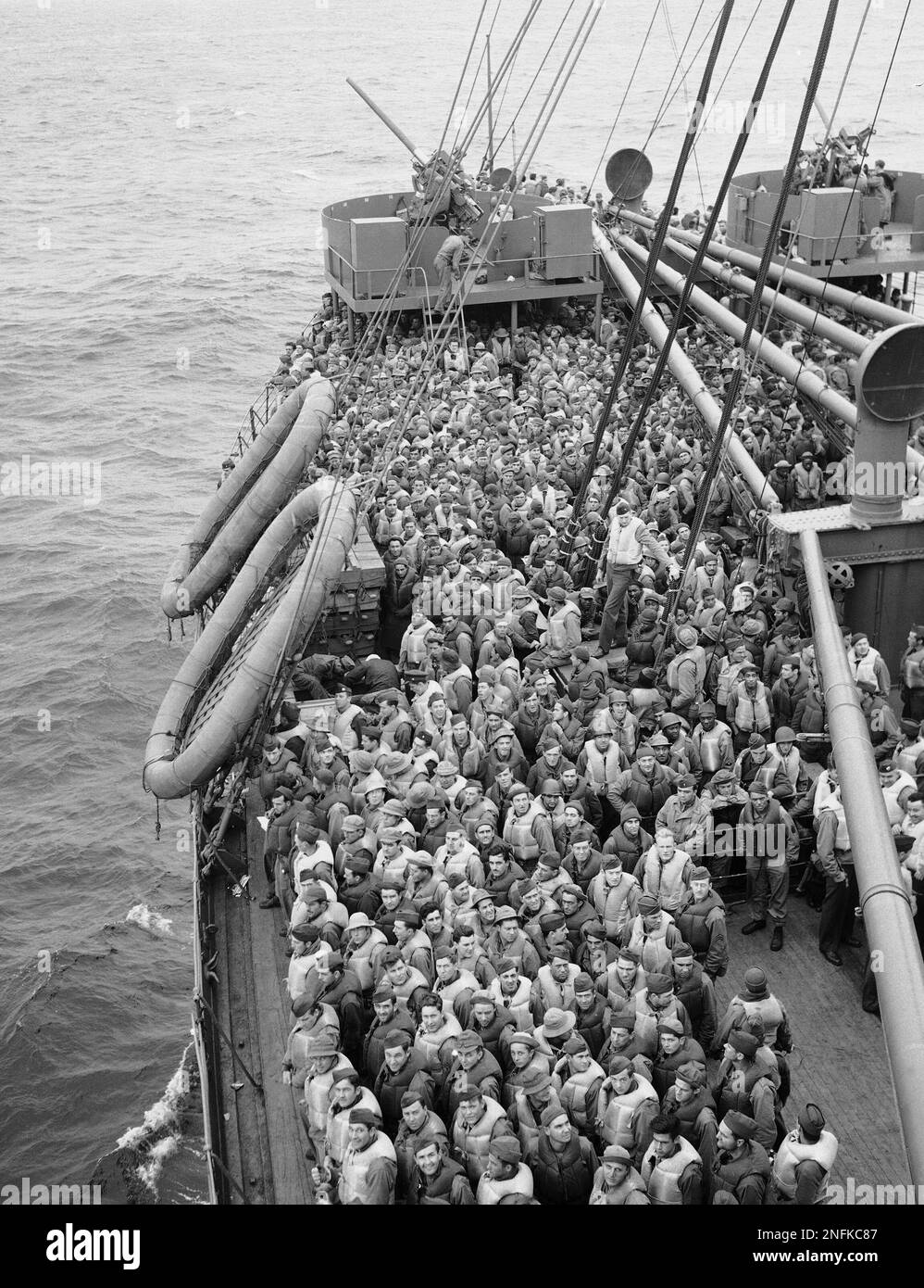 Wearing life-vests, American troops crowd the deck of a transport ...