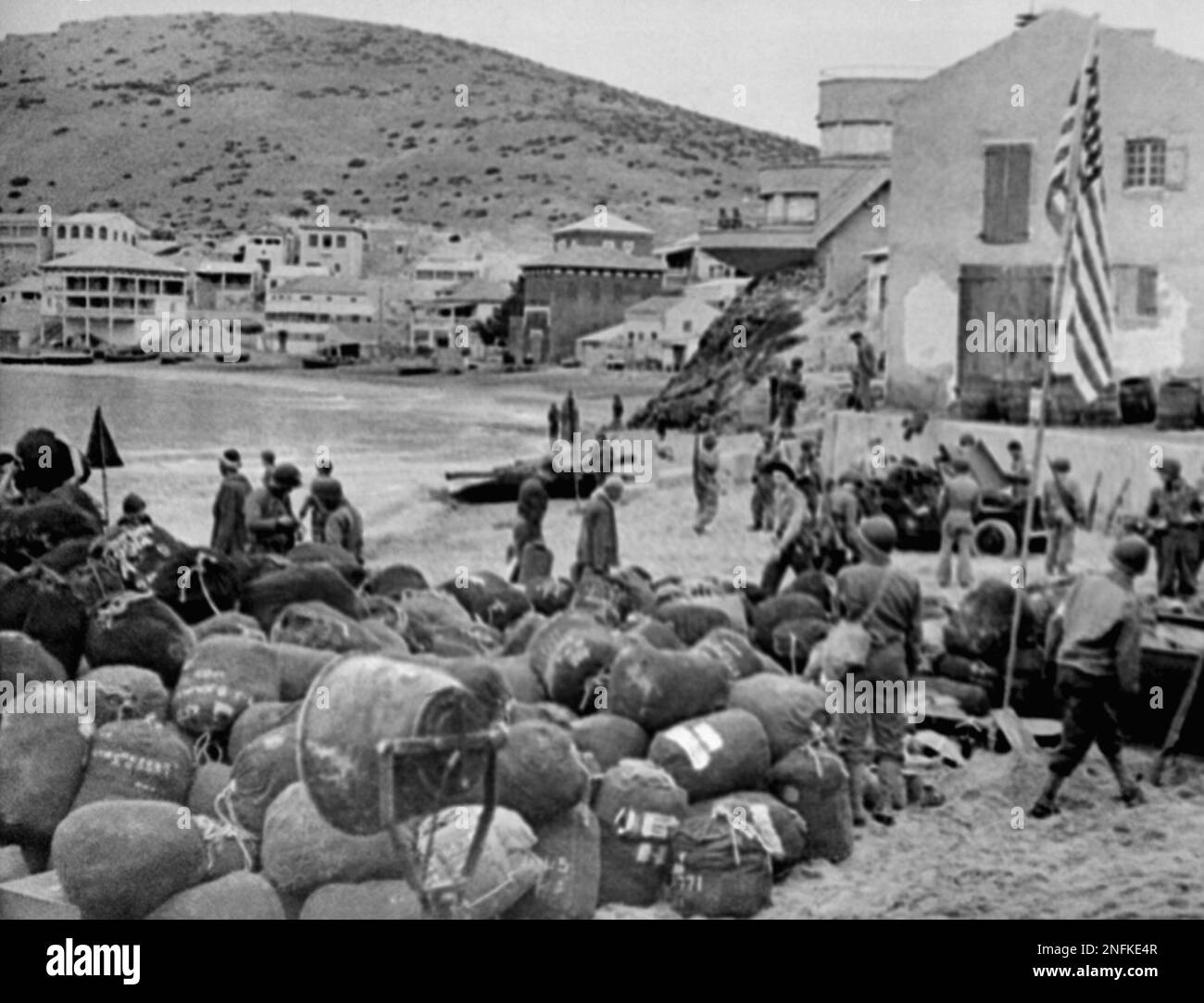 The American flag already has been raised over piles of war materiel ...
