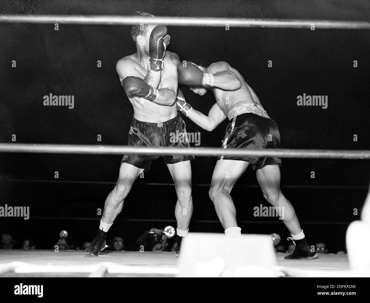 Joe Louis is shown boring in on the hapless Jack Roper shortly before ...