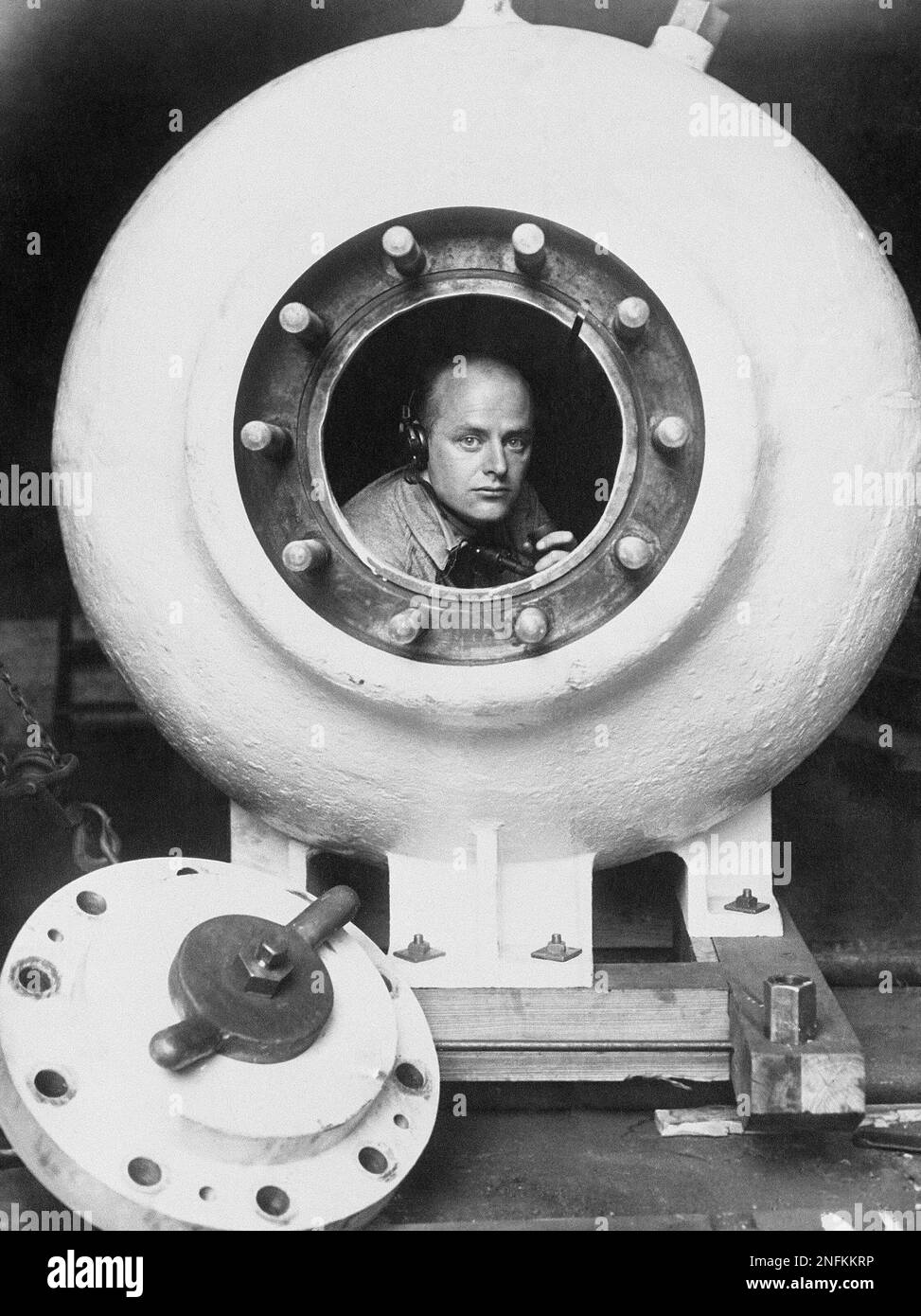 Otis Barton, inventor, is shown seated in his deep sea diving bell ...