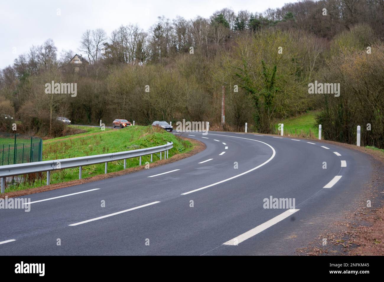 Road with white markings and a turn in the countryside in spring or ...