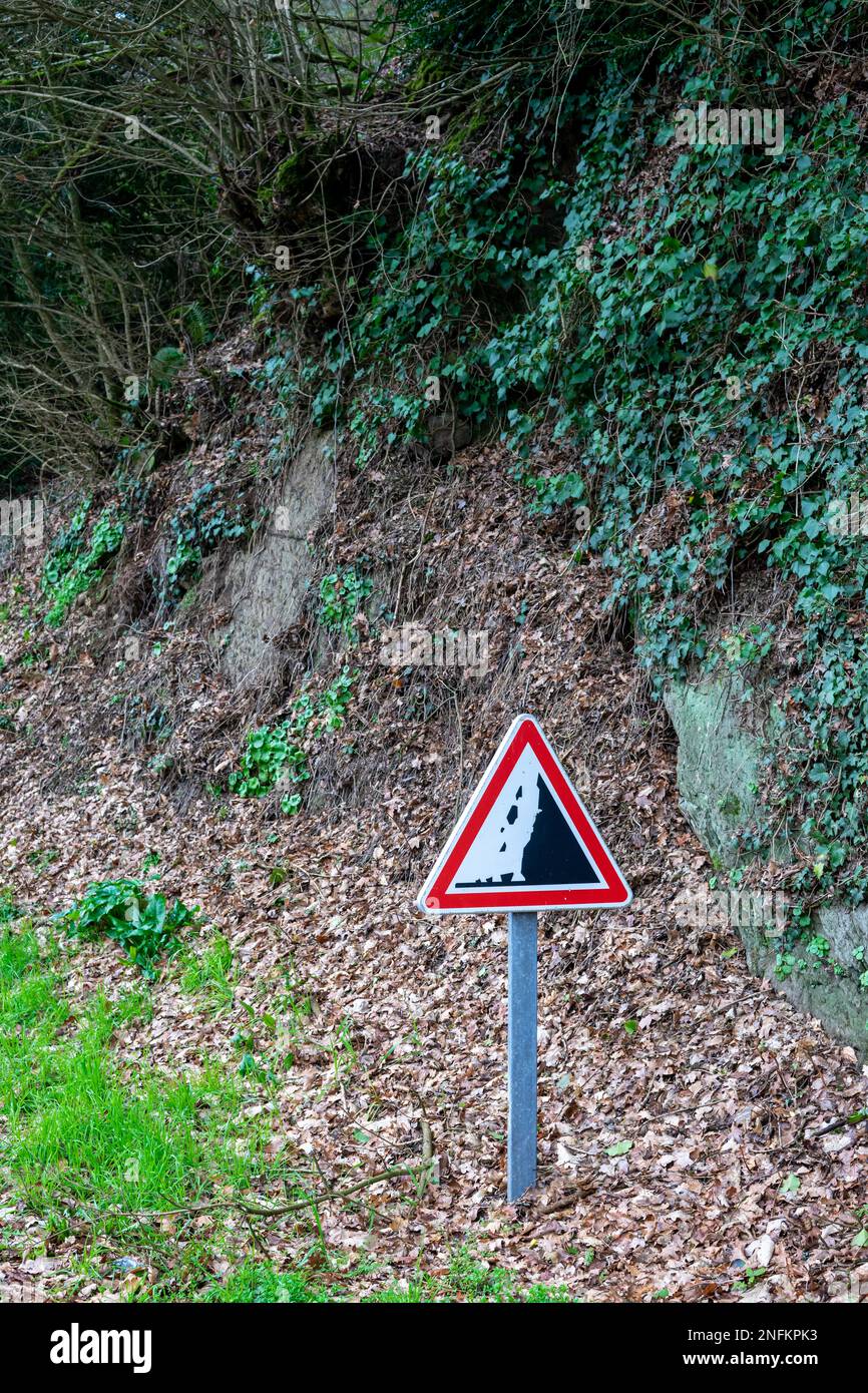 Road sign warning about falling stones near the mountain. Vertical ...