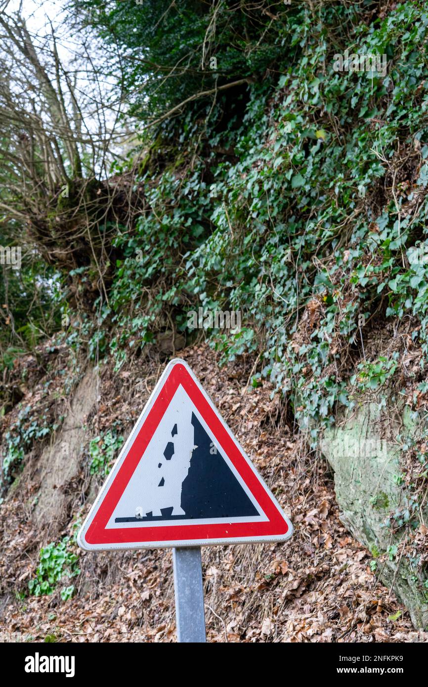 Road sign warning about falling stones near the mountain. Vertical ...