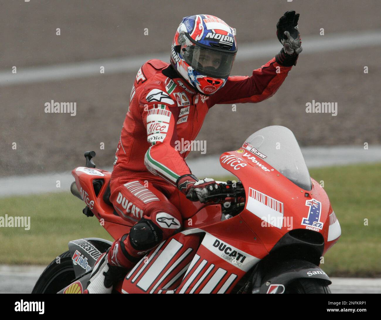 Australian rider Casey Stoner waves from his Ducati bike after he won ...