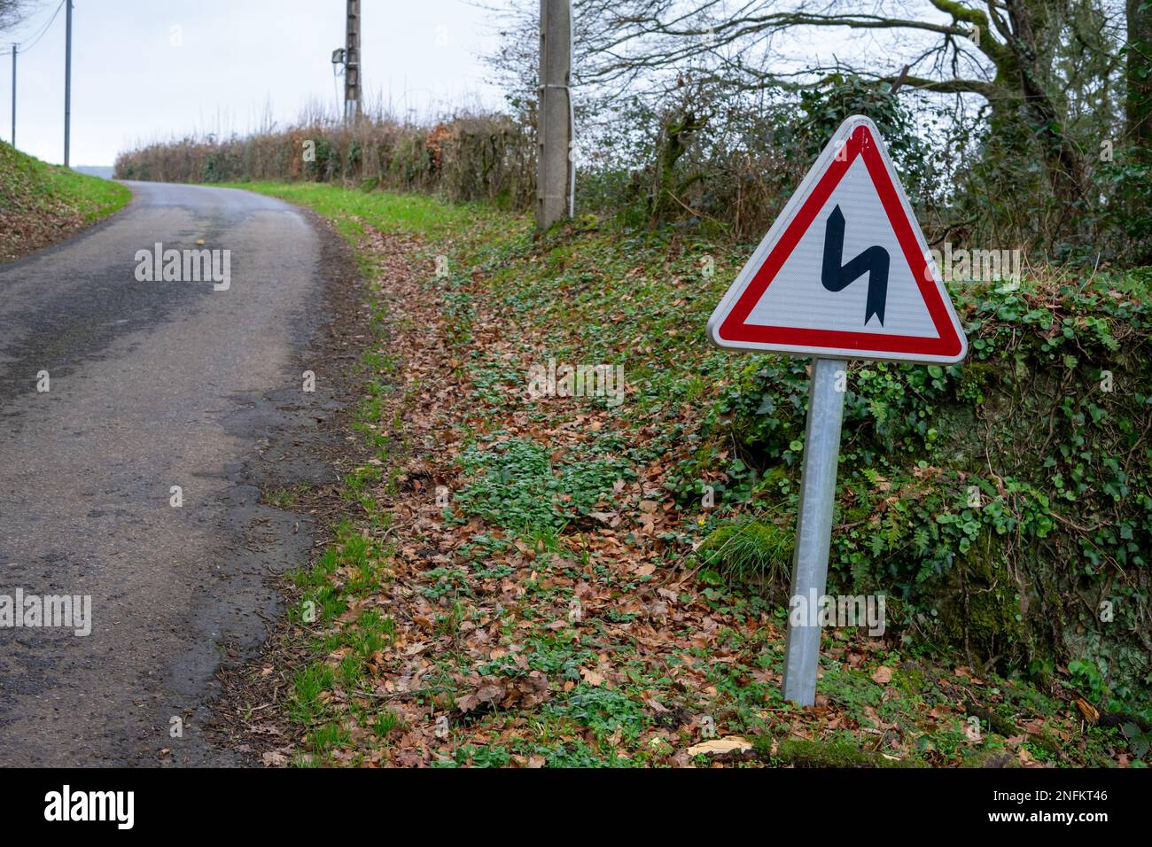 Road in the countryside and a sign of several turns. Warning sign for ...