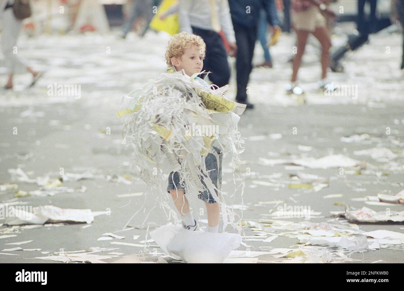 Five-year-old Julian Himes carries a load of ticker tape after a parade ...