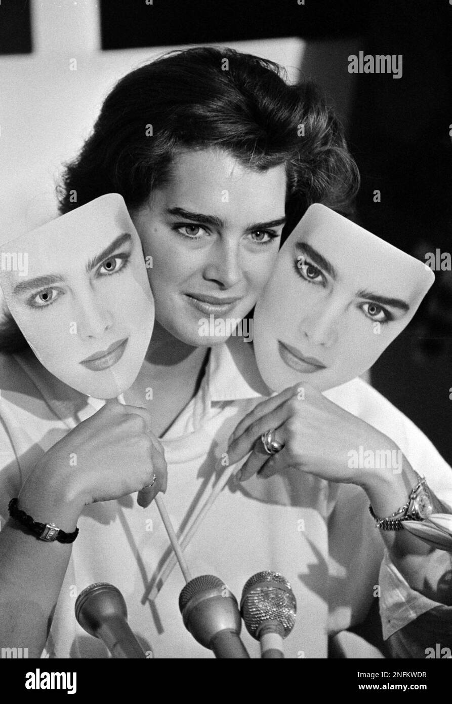 Actress-model Brooke Shields holds up two masks of her own face at the ...