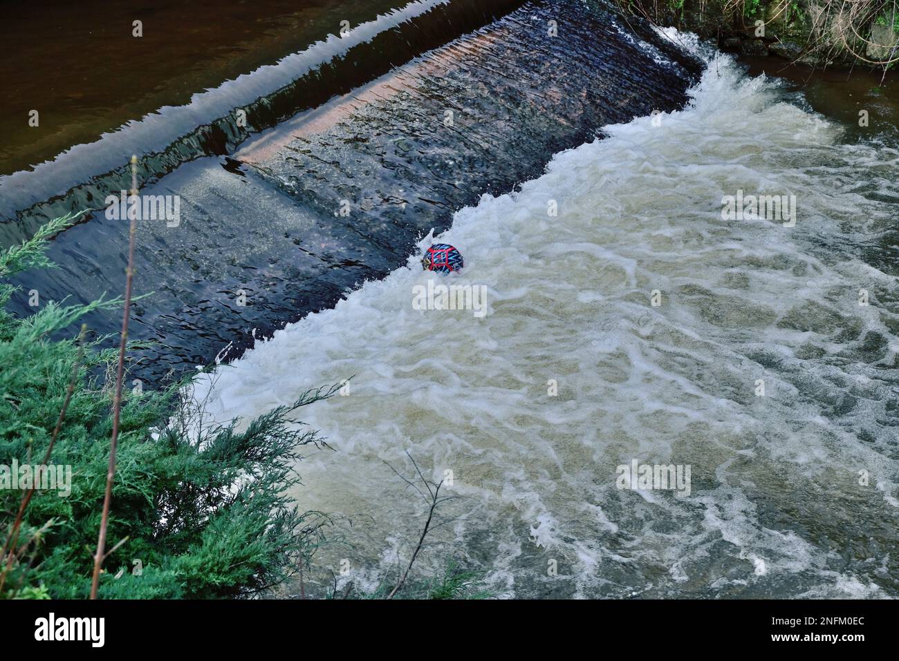 A football trapped in the water at the base of a weir, where it was ...