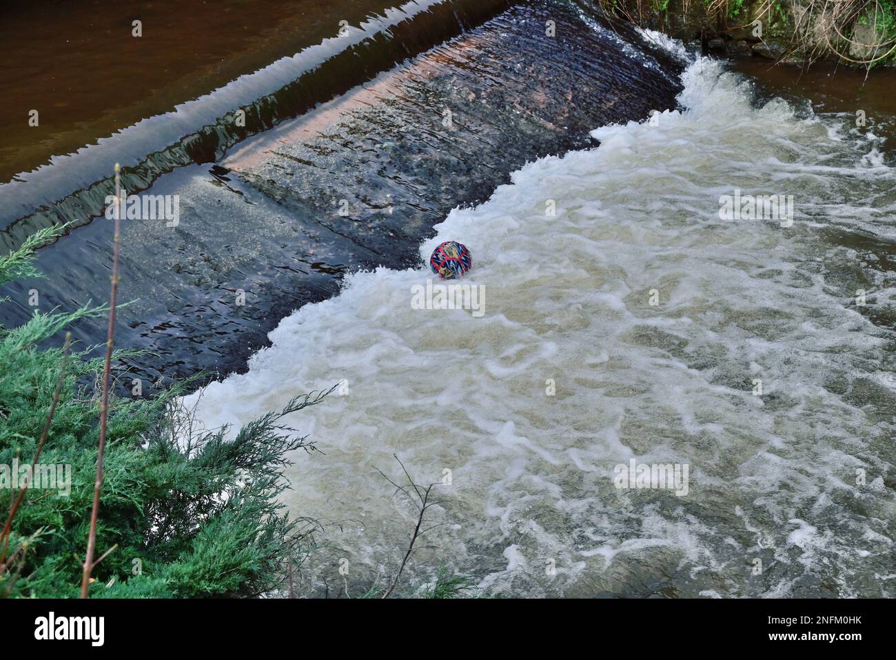 A football trapped in the water at the base of a weir, where it was ...
