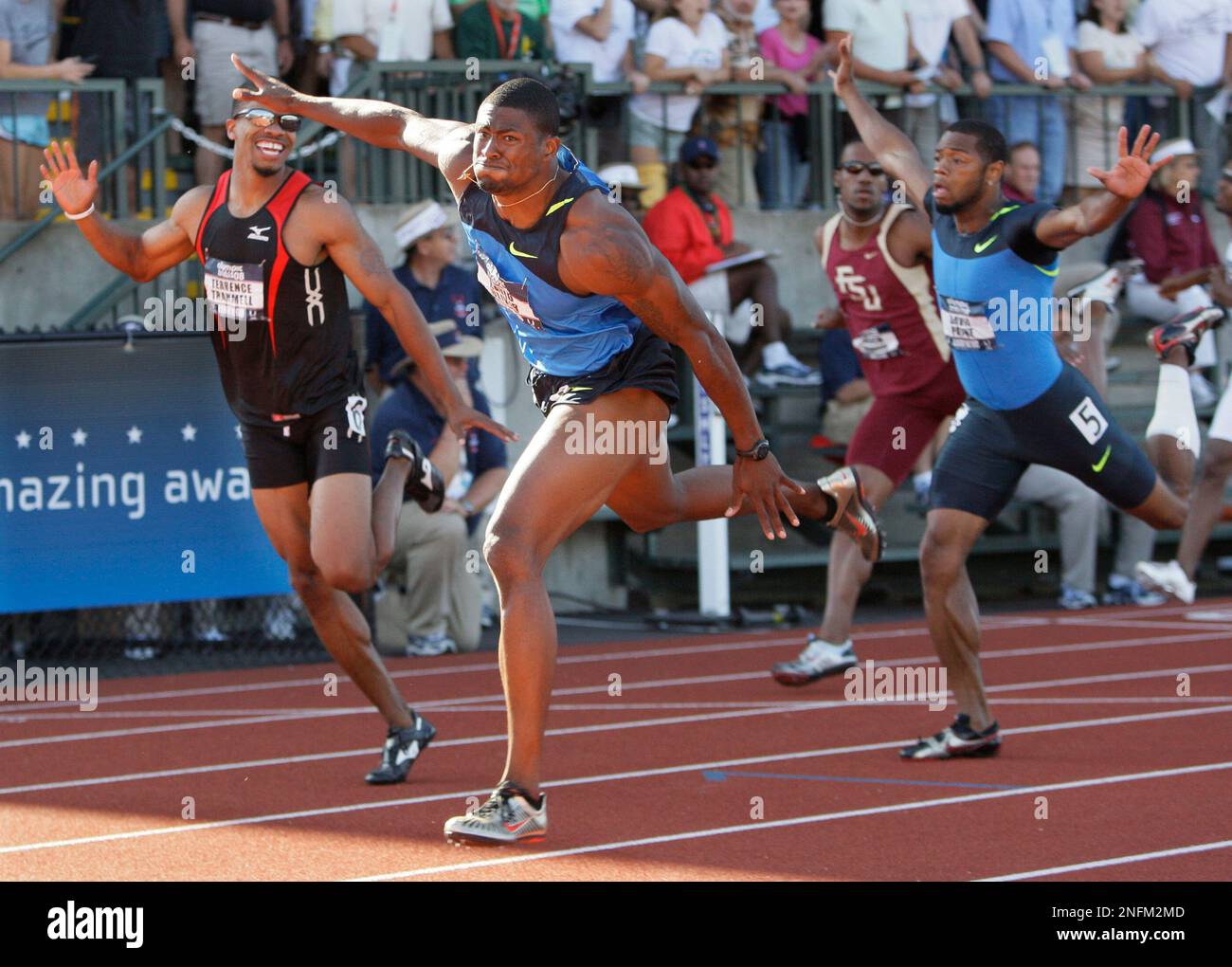 David Oliver crosses the finish line ahead of Terrence Trammell, left ...