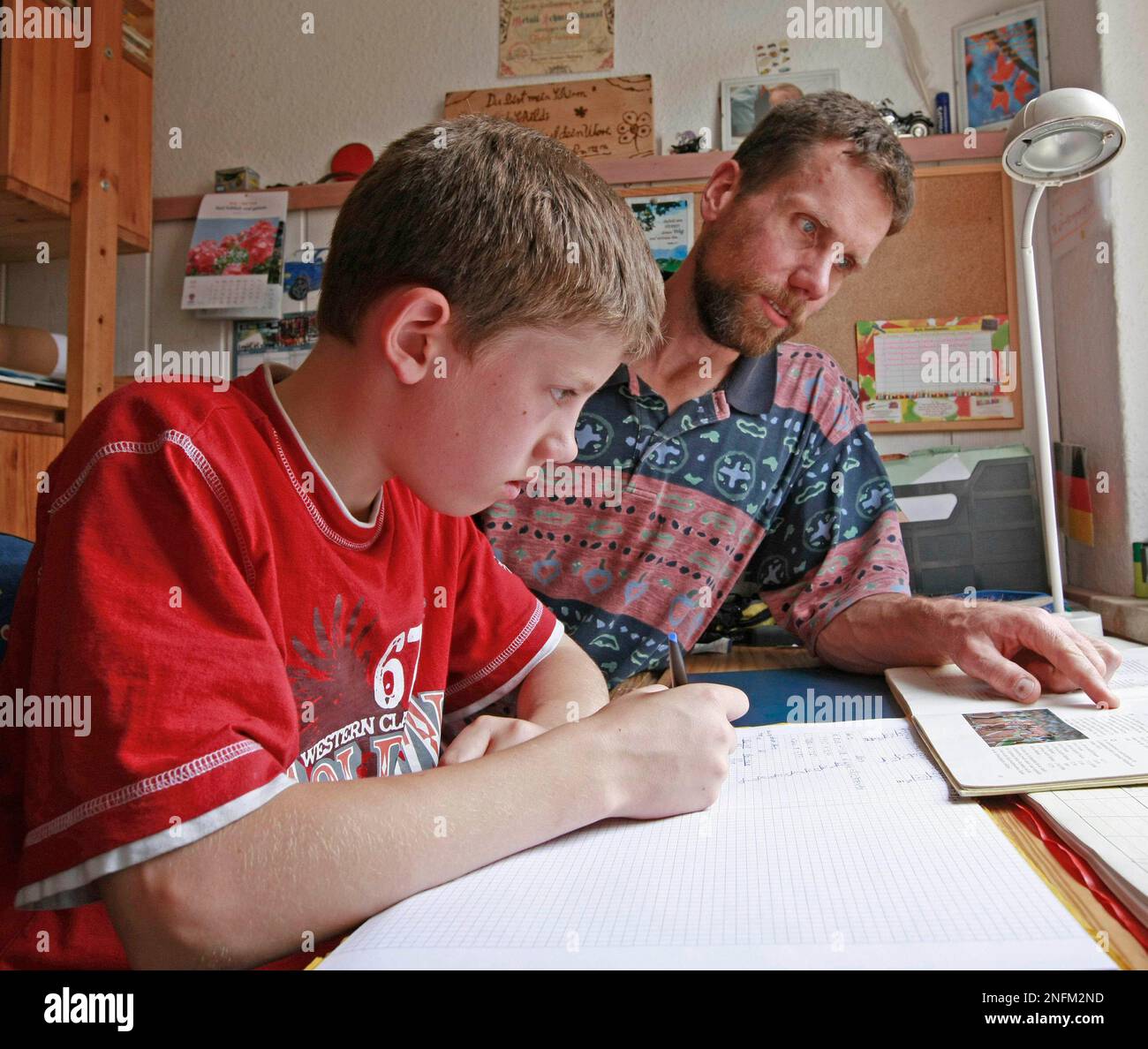 Der Vater Juergen Dudeck, 47 Jahre alt, rechts, unterrichtet sein Kind ...