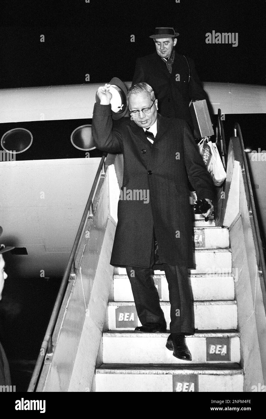 Secretary General of United Nations Organization, U Thant raises his hat as he leaves his plane ...