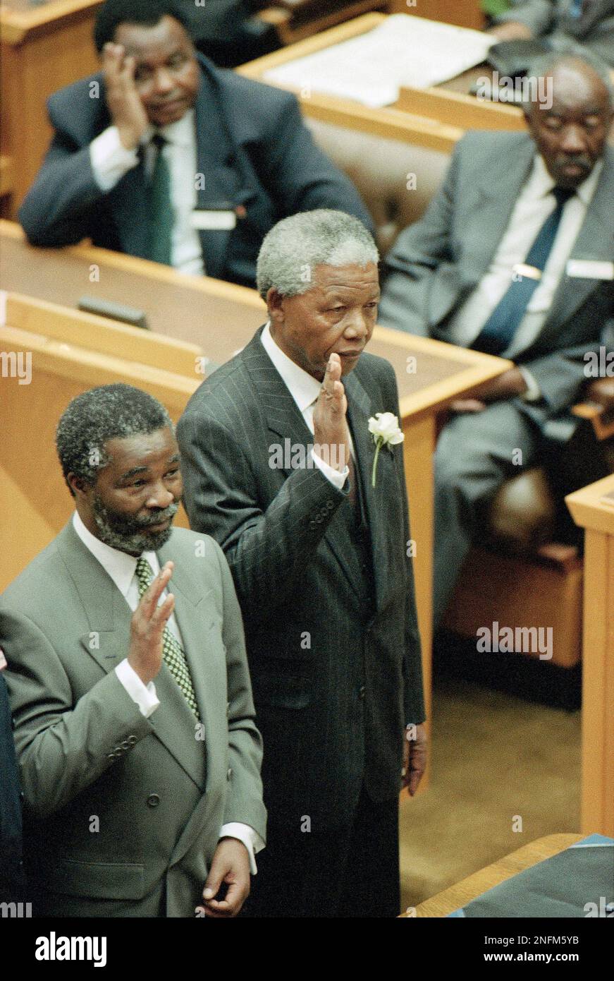 President-Elect Nelson Mandela, right, raises his hand to pledge the ...