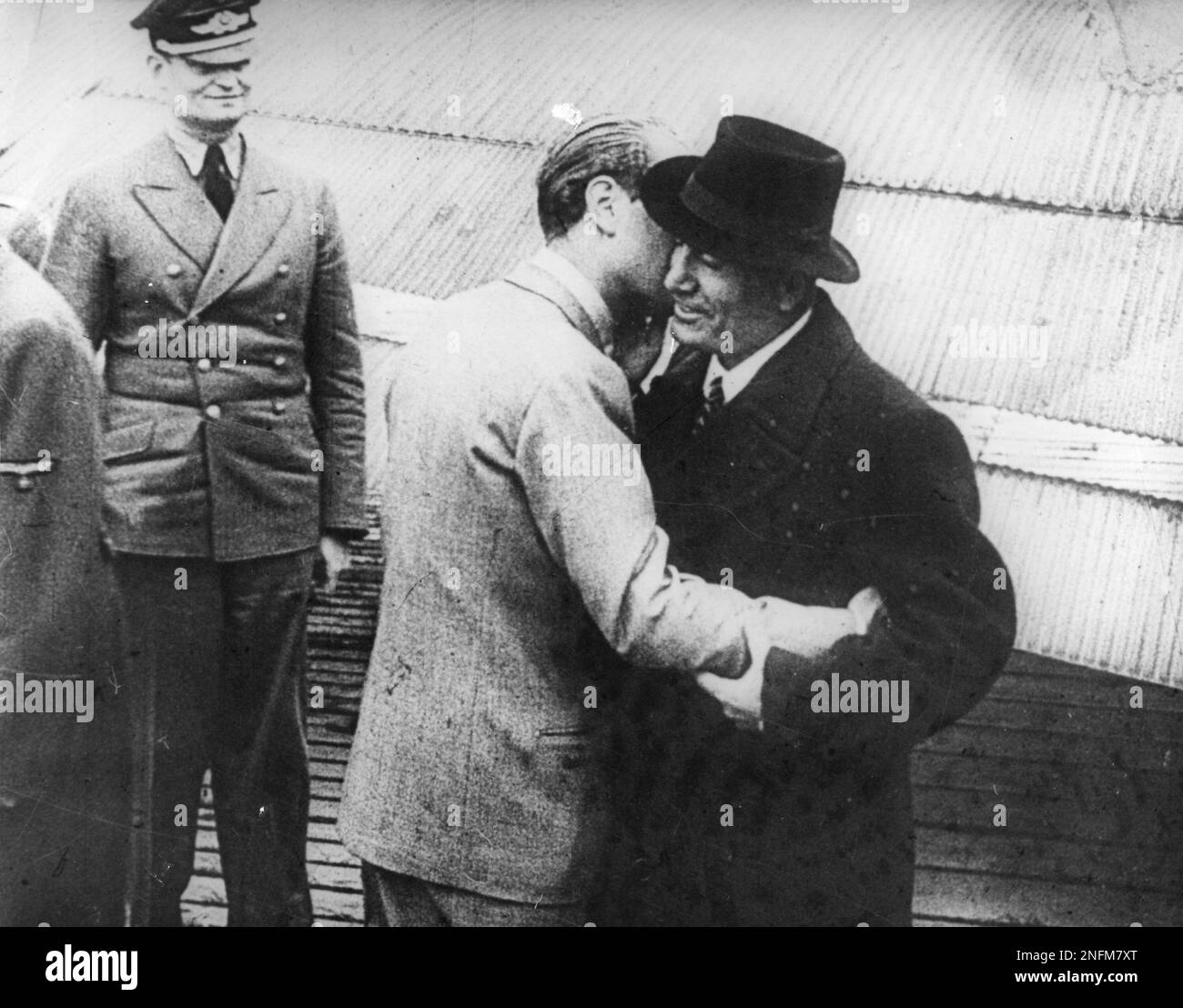 An unidentified man kisses Benitio Mussolini as he welcomes him at his ...