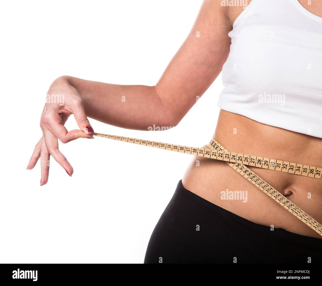 A woman in a white crop top and black yoga pants wrapping a tape ...