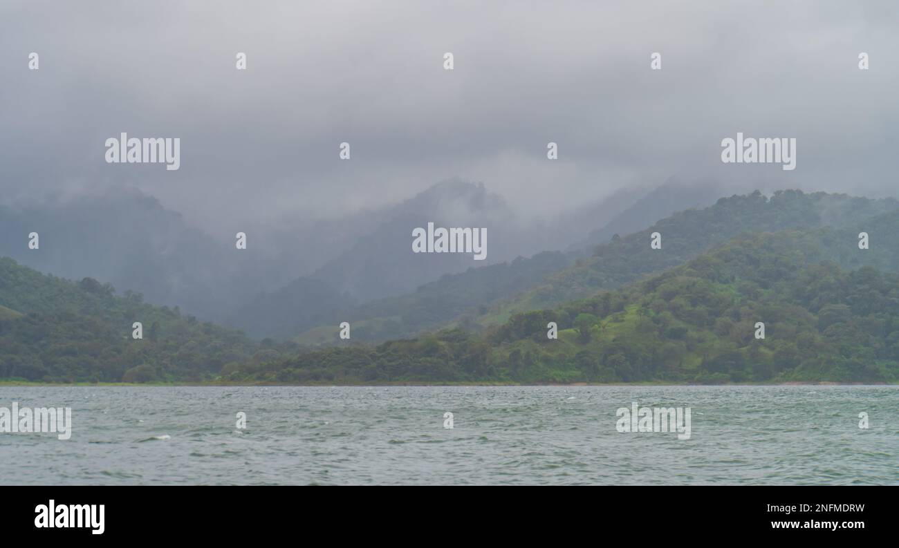mist and clouds over the lush tropical landscape along Lake Arenal in ...