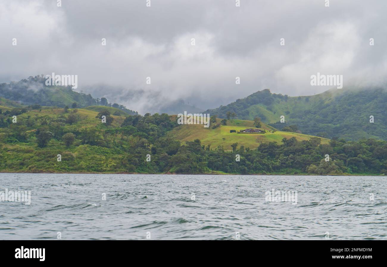 mist and clouds over the lush tropical landscape along Lake Arenal in ...