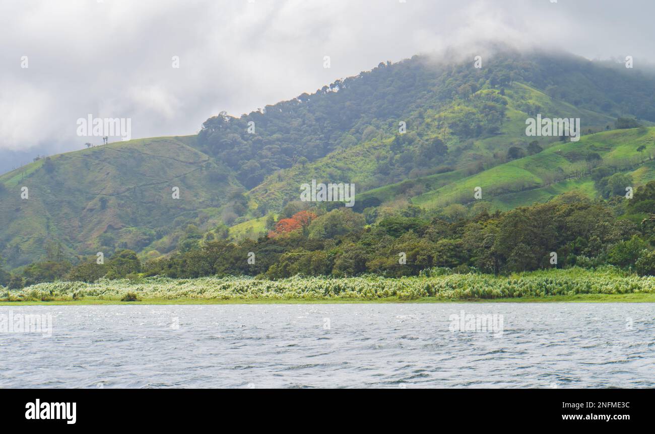 mist and clouds over the lush tropical landscape along Lake Arenal in ...