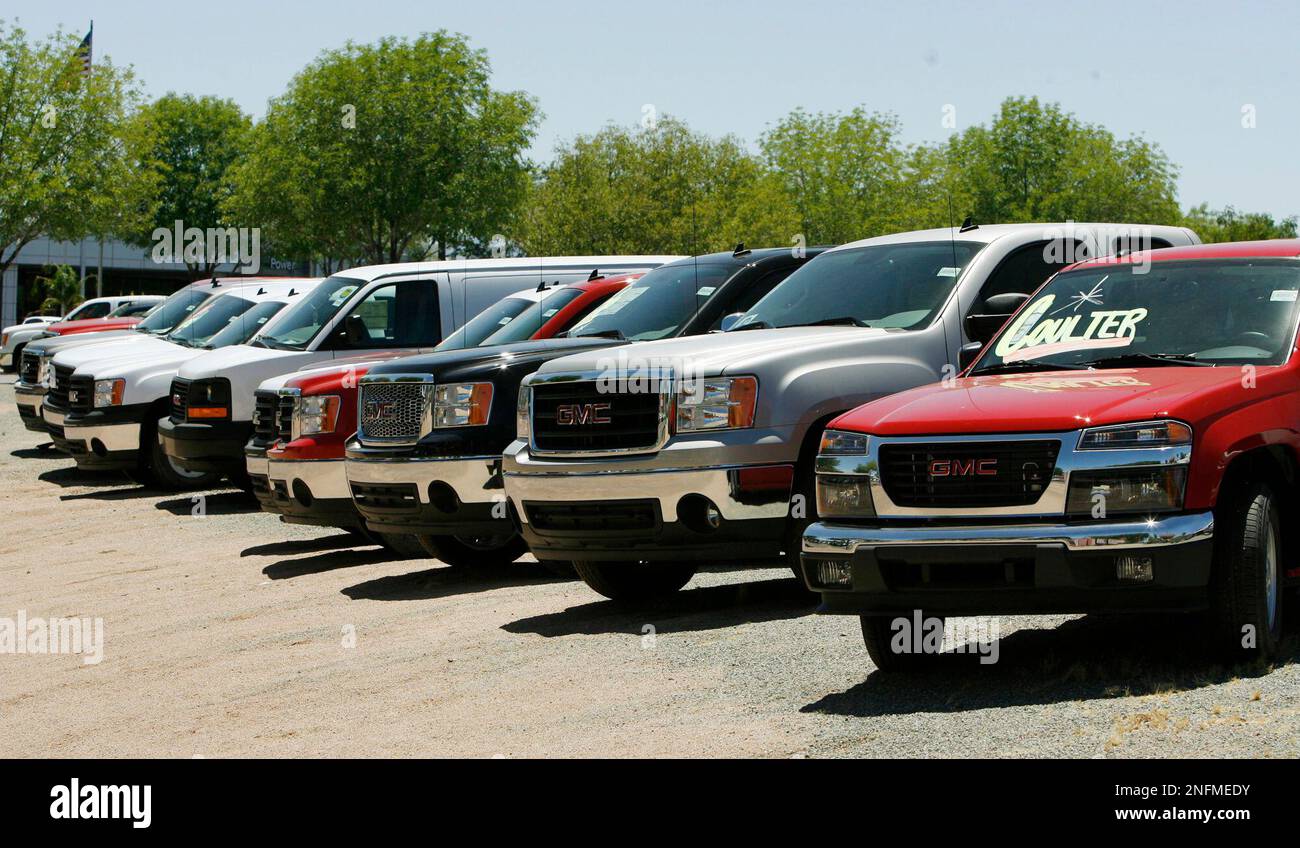 A line of pickup trucks and other large vehicles fill an overflow lot ...